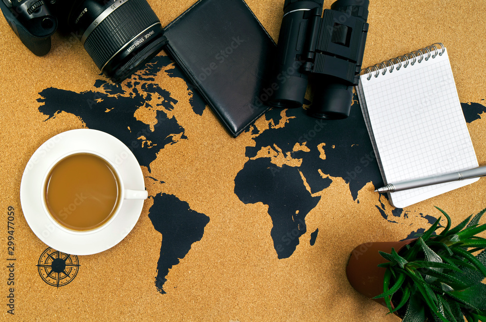 Cup of hot coffee on a map with camera, binoculars, passport, house ...