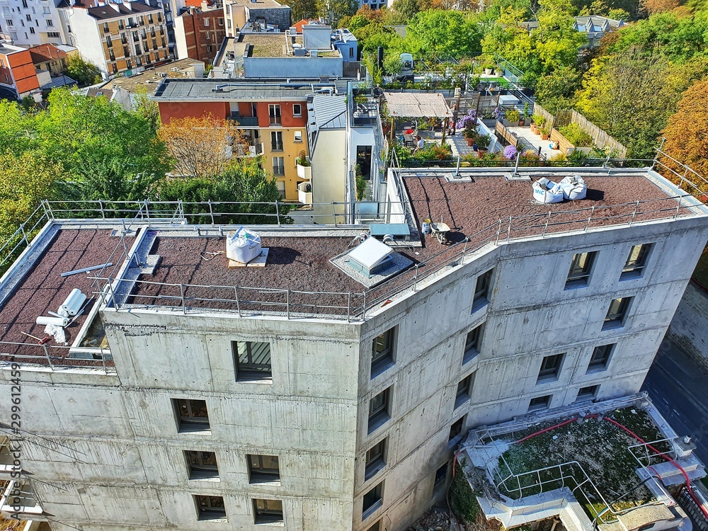 Vue aérienne d'un immeuble en construction et d'un toit terrasse à côté ...