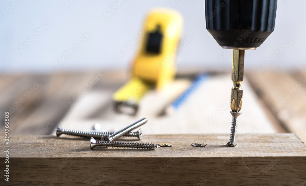 Set of silver screws on wooden top table background. One of them ...