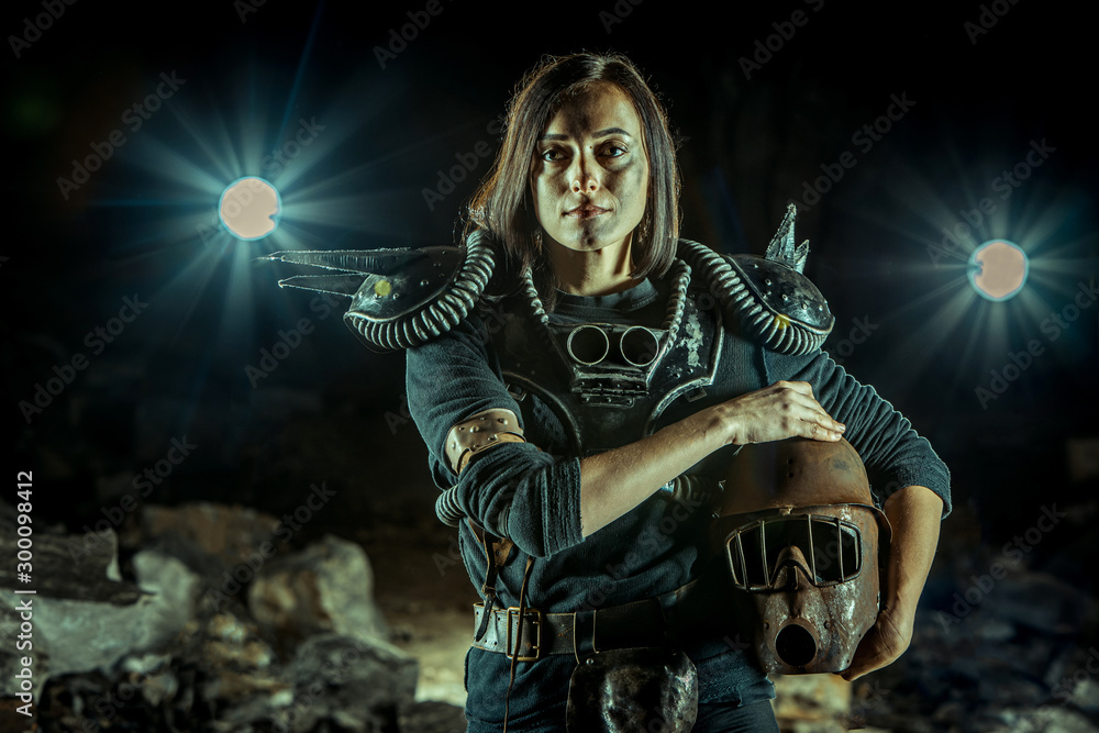 Post-apocalyptic woman with the rusty helmet in hands on the dungeon ...