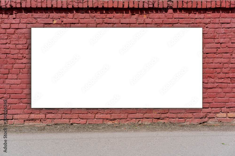 larger red brick fence texture on city street, asphalt pavement along ...
