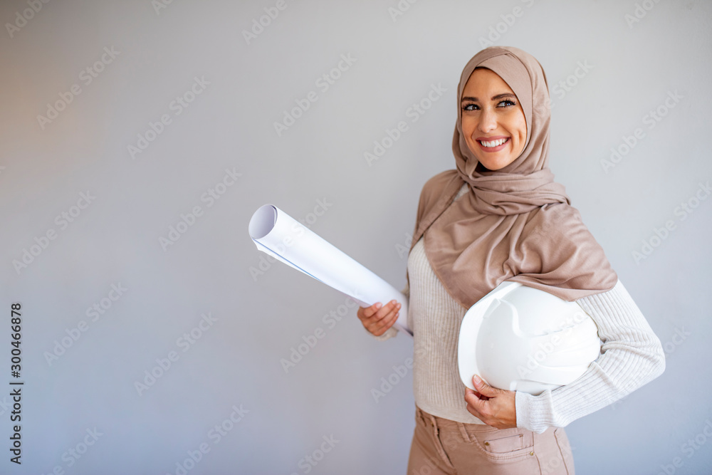 Young Muslim architect-woman wearing a protective helmet standing on ...
