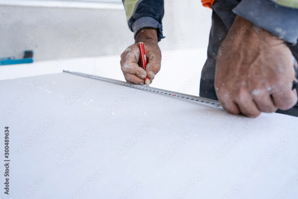 Worker use ruler measuring tape and pen to measure and mark the correct ...