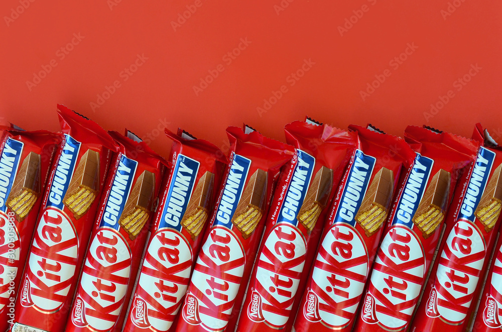 Kit Kat chocolate bars in red wrapping lies on yellow background is now ...