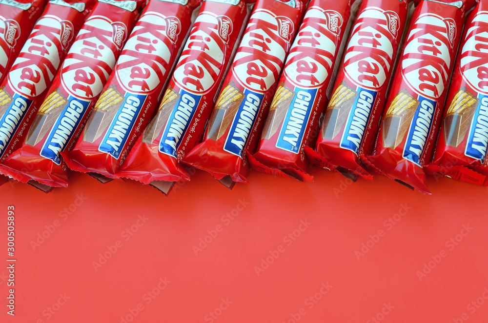 Kit Kat chocolate bars in red wrapping lies on yellow background is now ...