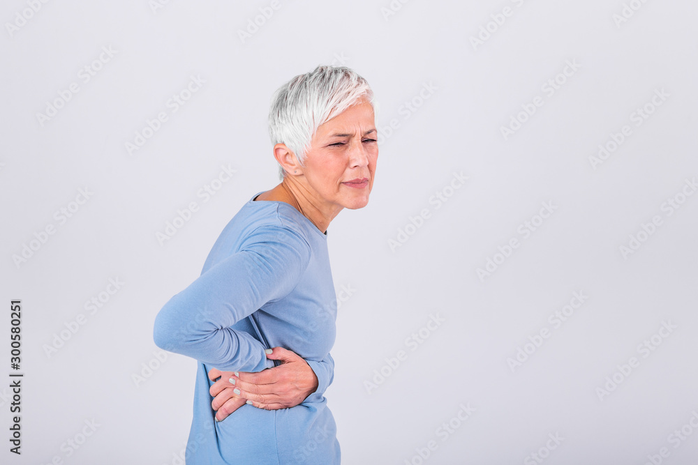 Elderly woman with gray hair touching her aching hip. Upset mature old ...