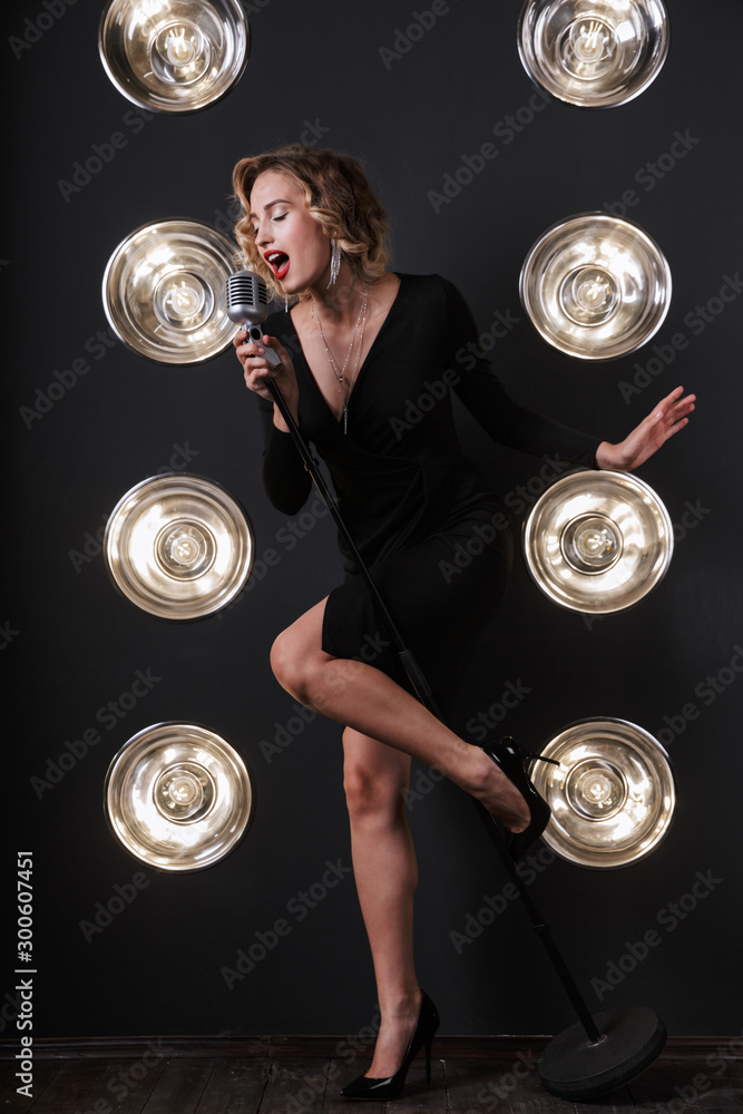 Full length image of fashion artist woman in dress singing into ...
