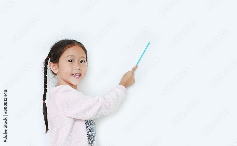 Happy little Asian child girl standing and pointing up present ...