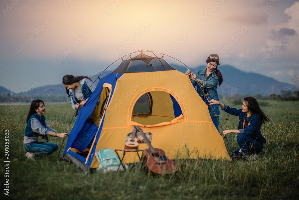 Group A girl friend in casual clothes and enjoys camping in the forest ...