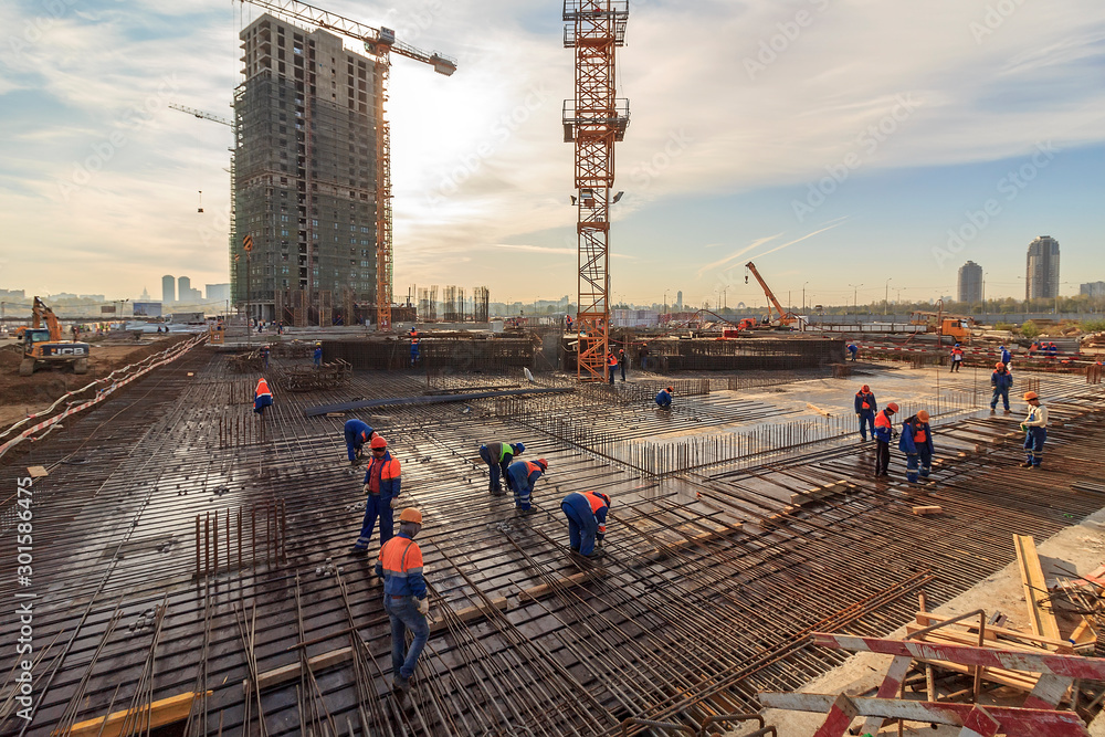 Bar bender fixing steel reinforcement for house concrete floor slab. construction worker ...