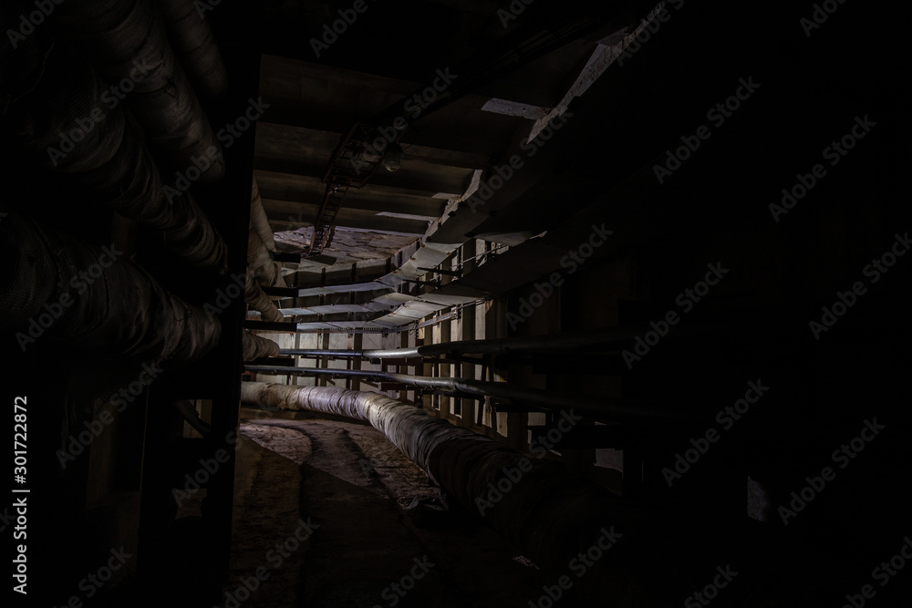Underground concrete utility tunnel with pipes and wires. This tunnel ...