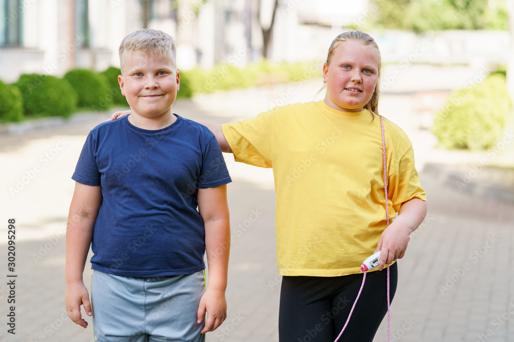 Fat boy and girl posing outdoors during a fitness class. Stock Photo ...