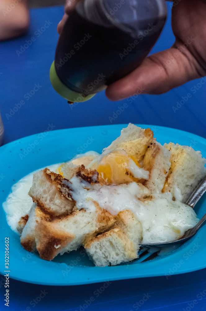 Stock-Foto „The classic “roti bakar telur goyang” or toast with a half ...