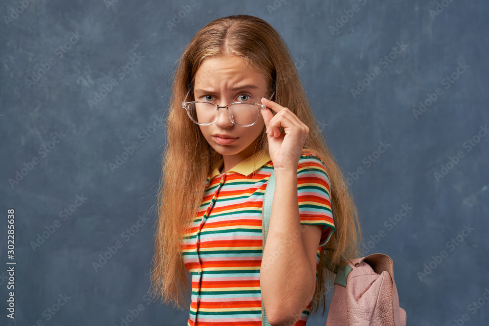 Worried puzzled student, looks stressfully and nervously through ...