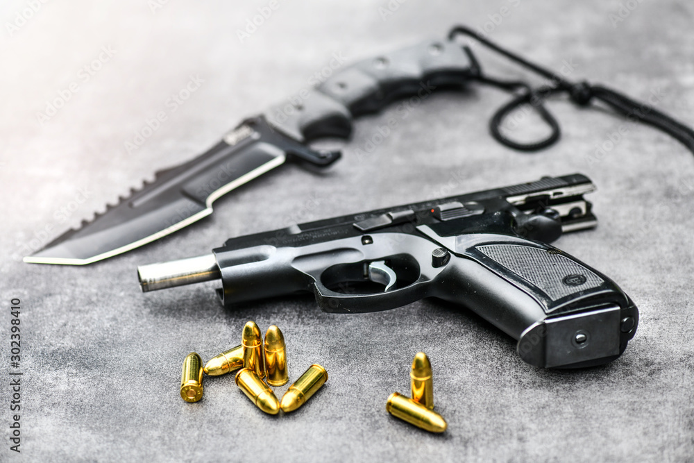 Gun with ammunition, tactical knife on stone background. 9 mm pistol ...