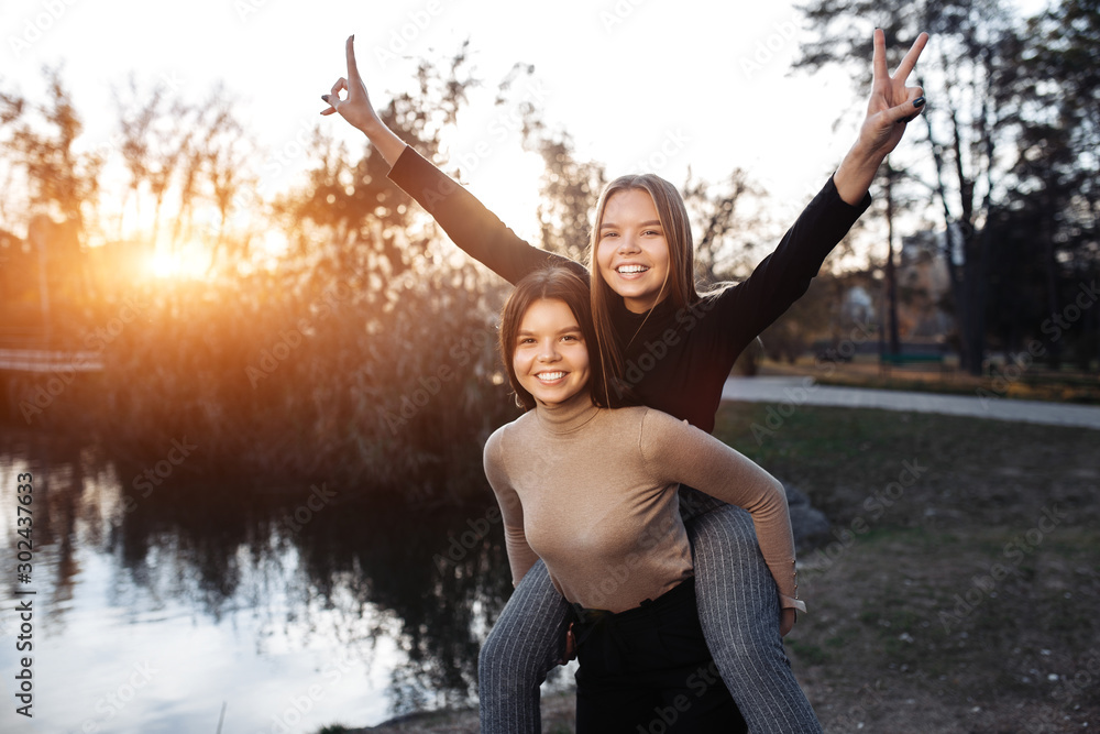 Positive two young twin sisters in casual outfit with bright smile ...