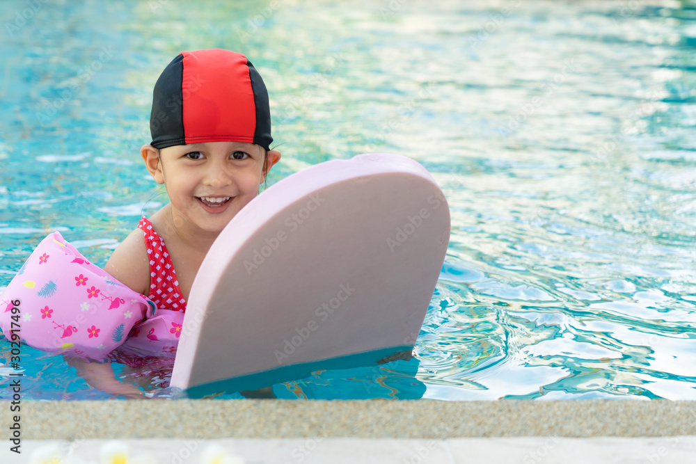 Adorable 3 years old girl is floating in the swimming pool with big ...