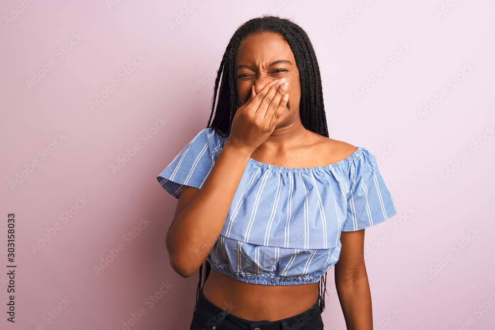 African american woman wearing striped t-shirt standing over isolated ...