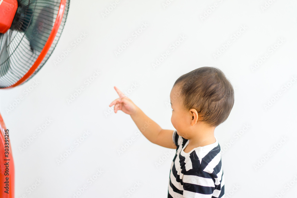Asian baby toddler boy put his finger into electric table fan alone ...