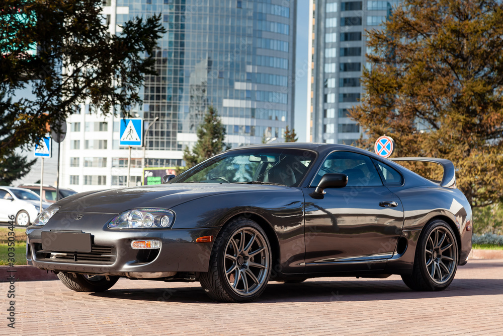Toyota Supra coupe front view in gray with a spoiler in park of city ...
