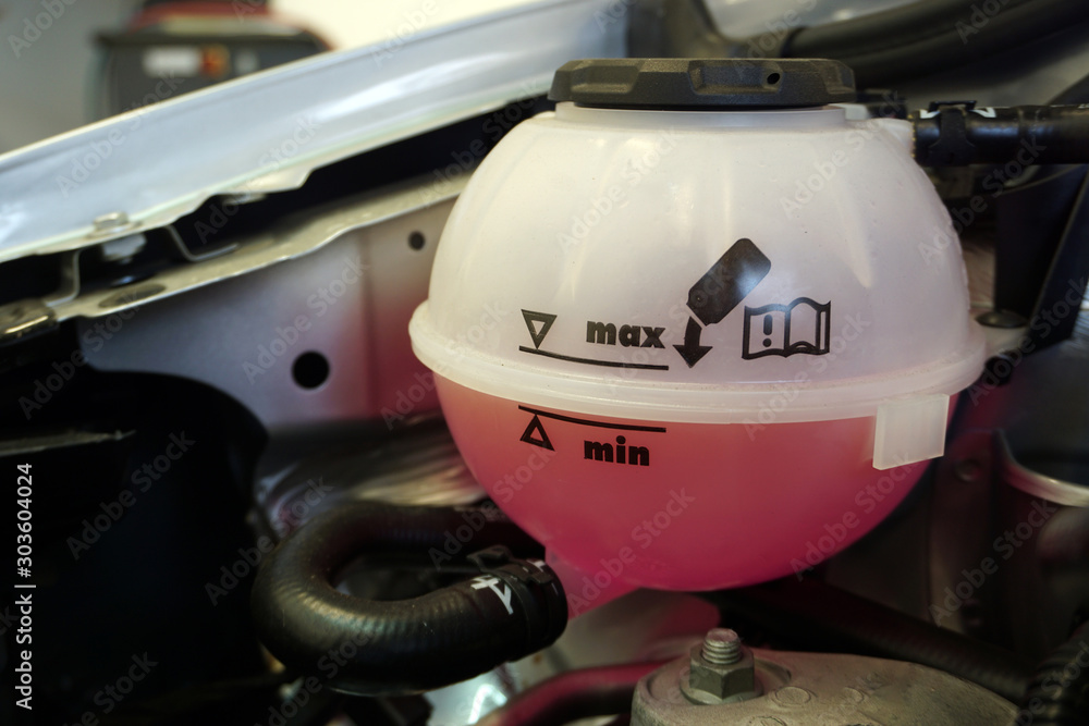 ภาพถ่าย Stock Close-up white expansion tank with pink antifreeze. Car ...