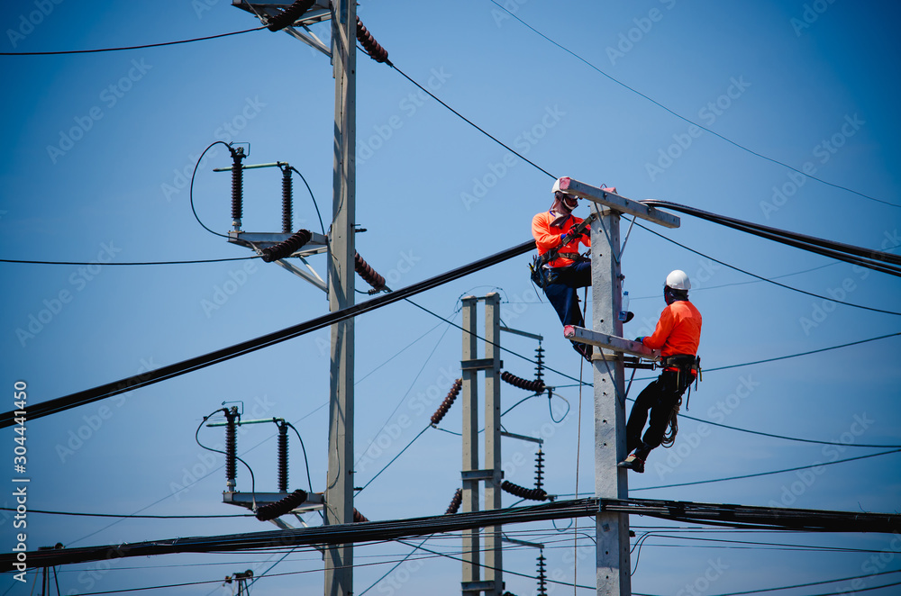 Electricians are climbing on electric poles to install and repair power ...