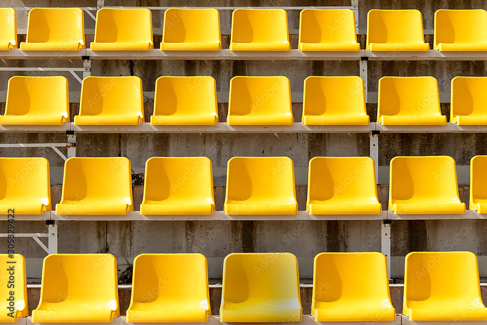 Yellow seats on stands of stadium in open. Rows are horizontal. On ...