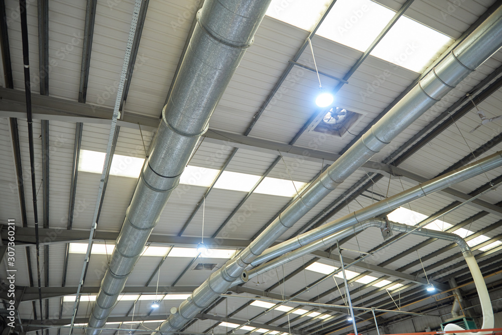 Industrial metal air flow and air conditioning pipes on the ceiling of ...