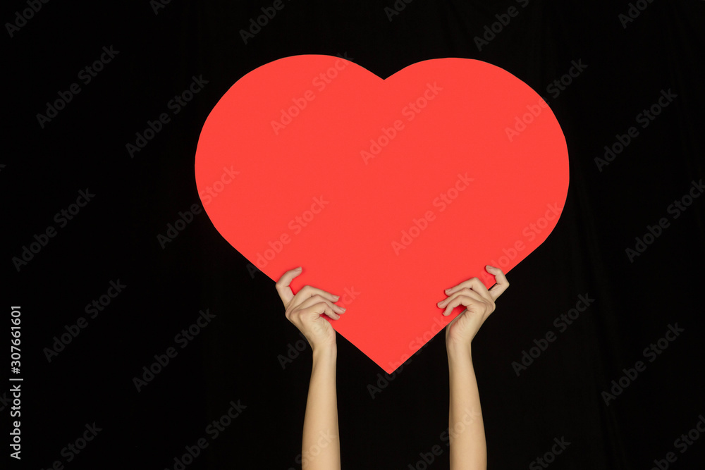 Hands holding the sign of heart on black studio background. Negative ...