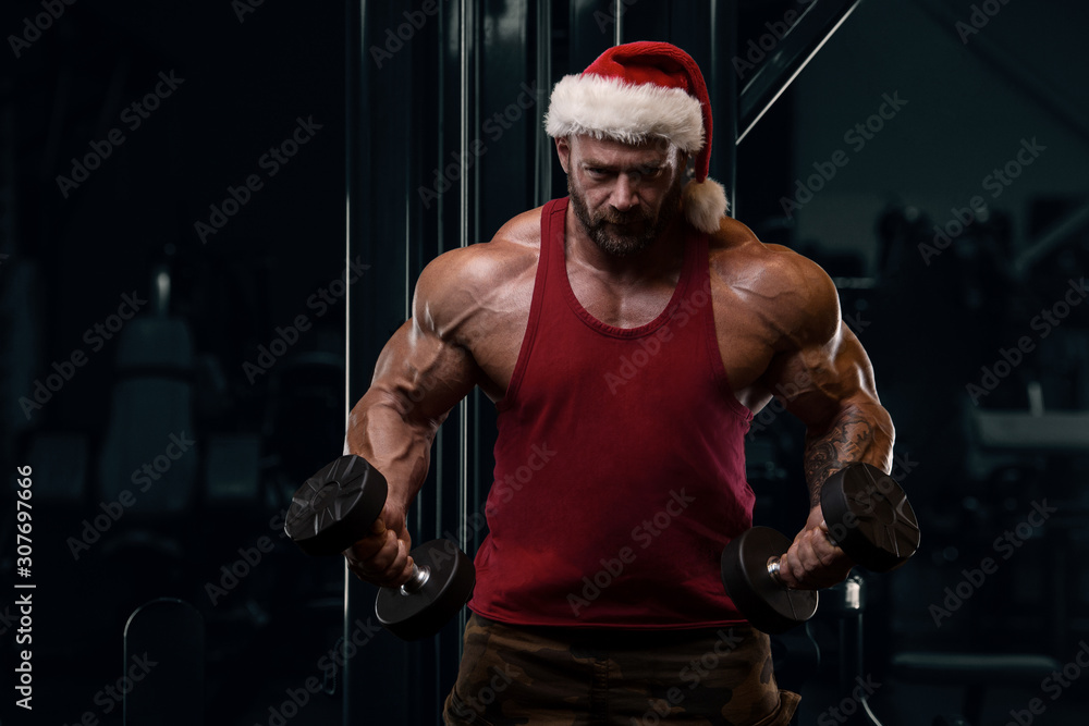 Bodybuilder in Santa Claus costume in the gym Stock Photo | Adobe Stock
