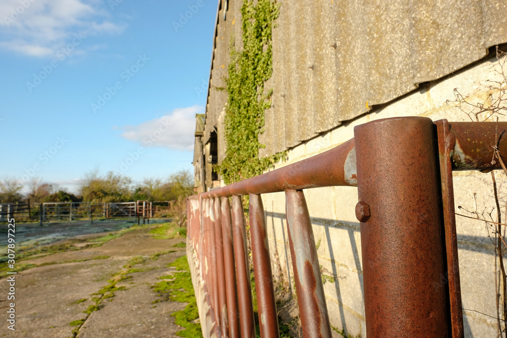Shallow focus detail of part of a gate and railings used to keep hay to ...
