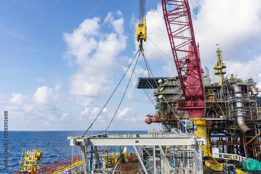 Offshore crane on board a construction work barge performing heavy ...