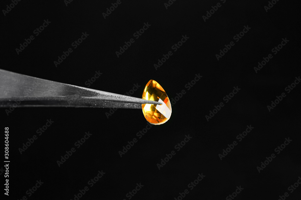 Pincers with precious stone for jewellery on dark background Stock ...