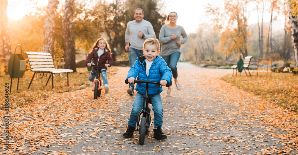 Lovely little kid running away on his byclies while her parents and ...