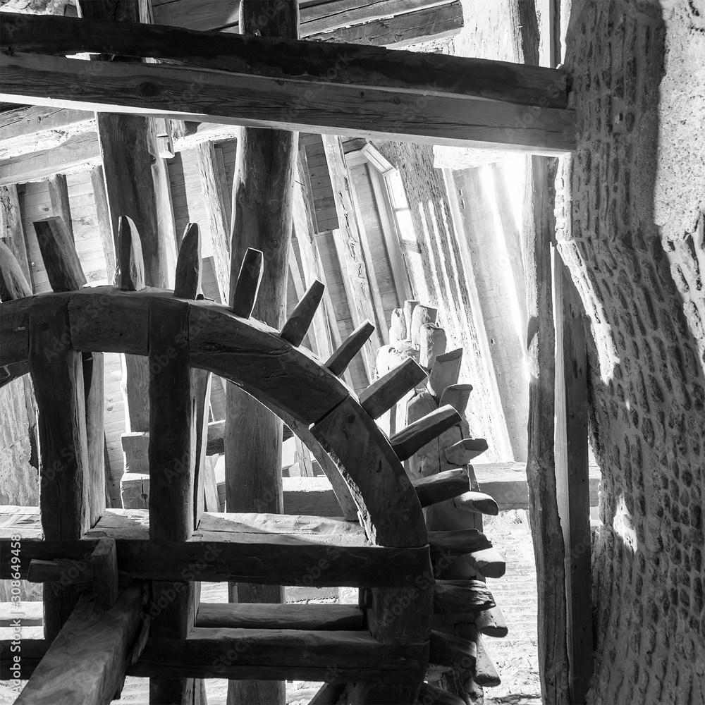 Black and white from below of aged water mill turning inside weathered ...