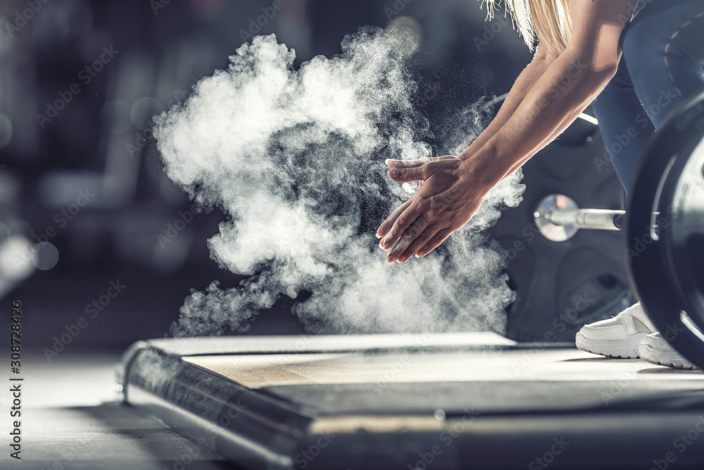 Muscular weightlifter woman clapping hands before barbell workout at ...