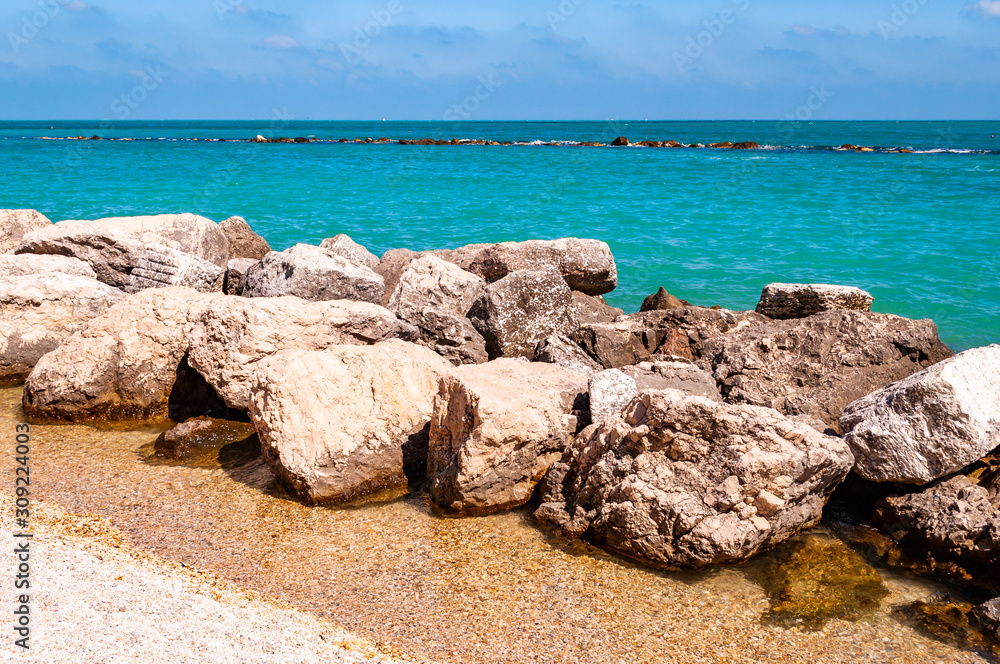 Massive stones rocks lying on the beach as a border between pebble ...