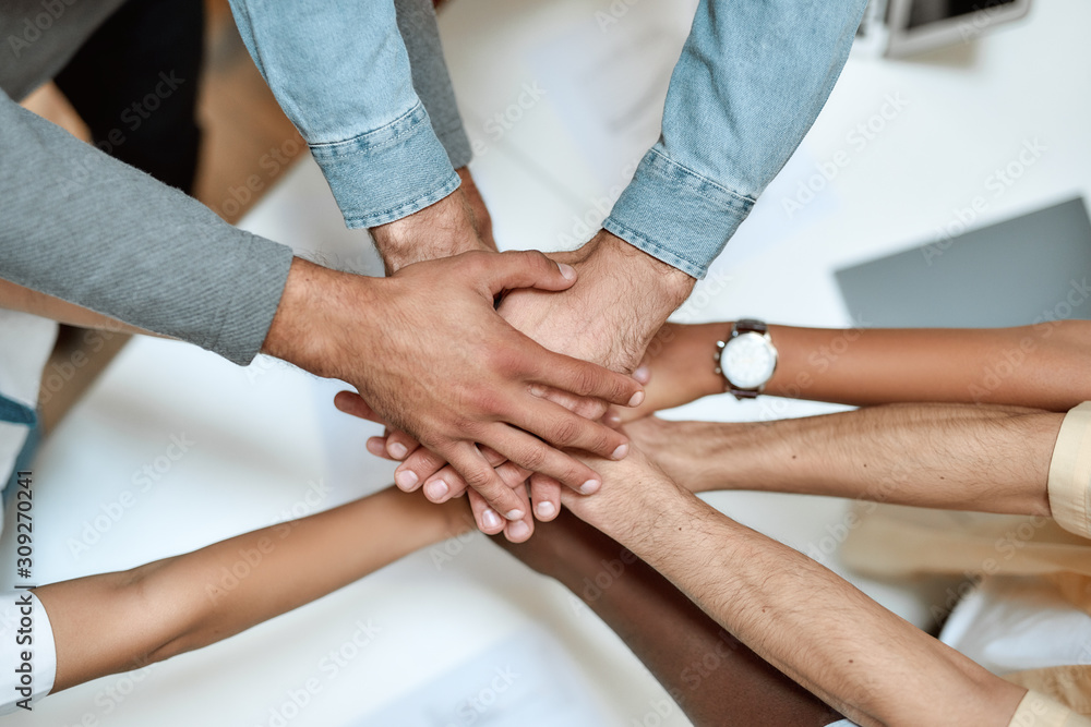 We always support each other. Multiracial group of people holding hands ...