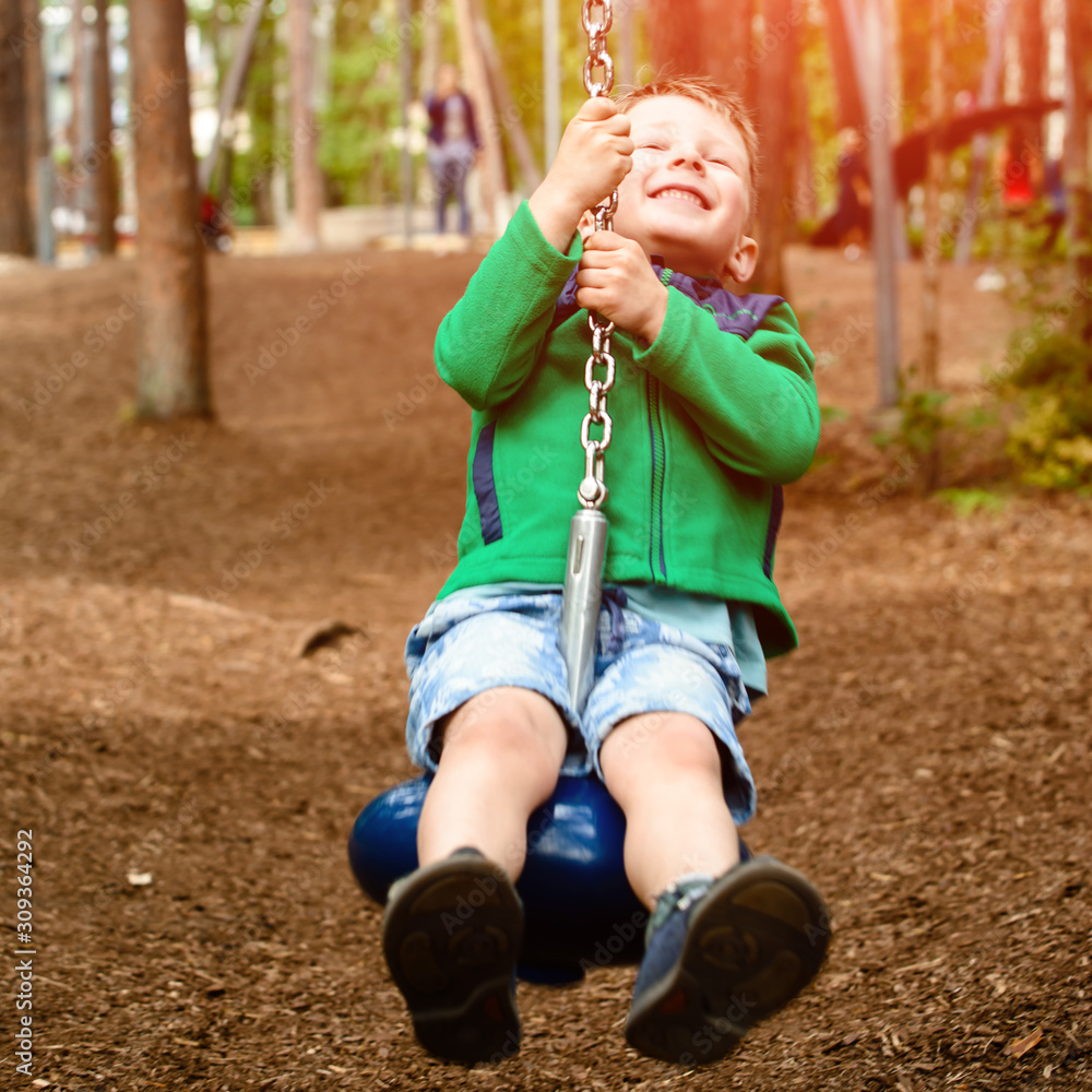 Child boy rides on Flying Fox play equipment in a children's playground ...