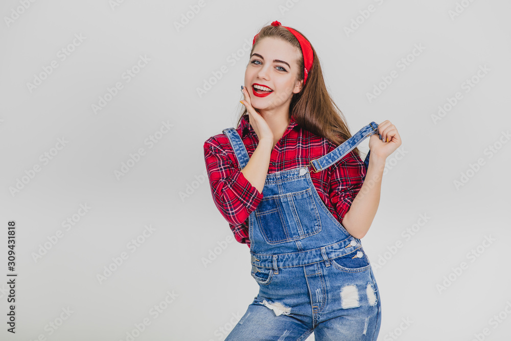 Beautiful young girl in red standing, keeping one hand on her cheek ...