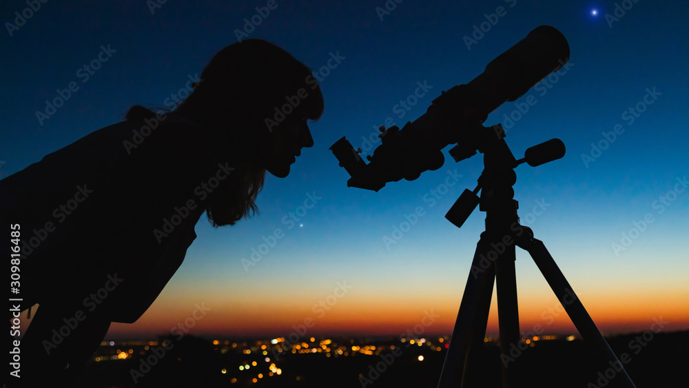 Astronomer with a telescope watching at the stars and Moon with blurred ...