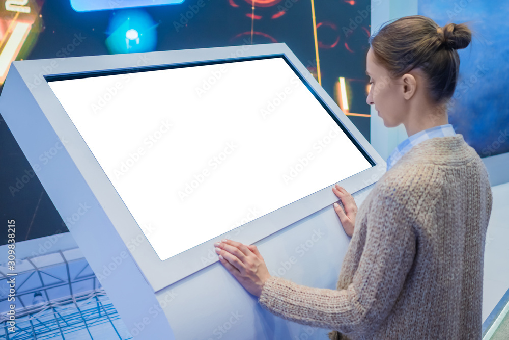 Mockup: woman looking at blank white interactive touchscreen display of ...