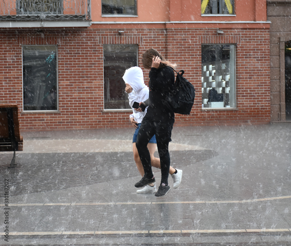 People running down the street on rainy day. Intentional motion blur ...