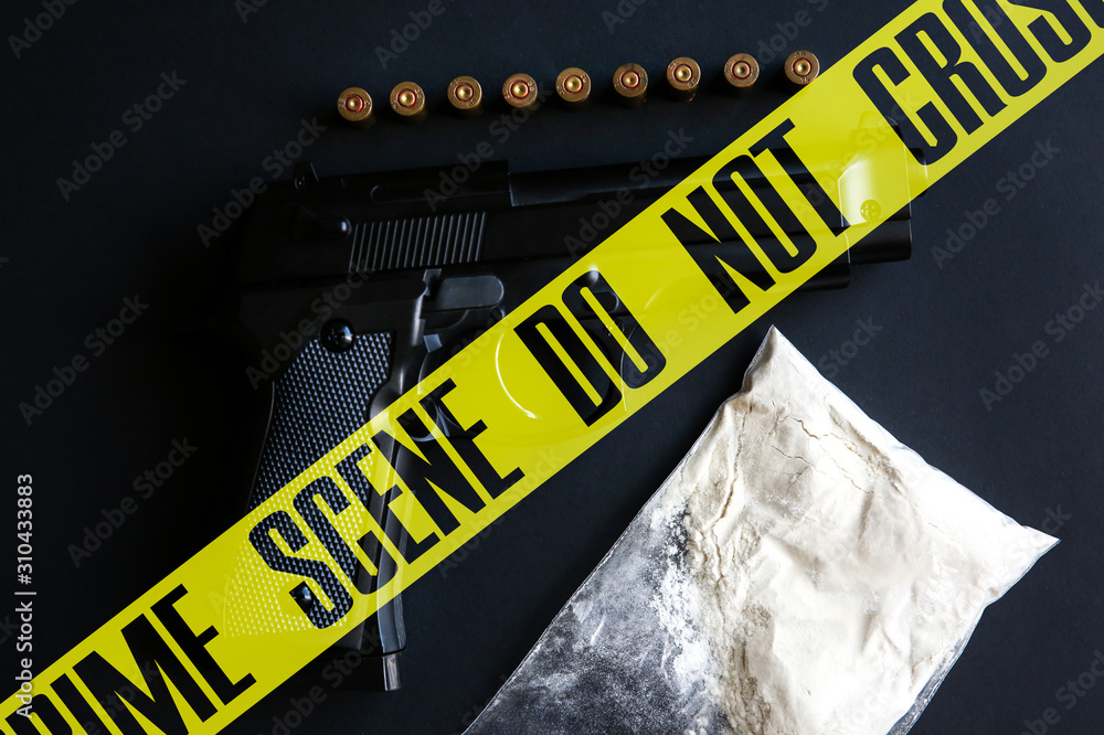 Gun with bullets lying on the table. Crime scene do not cross tape ...