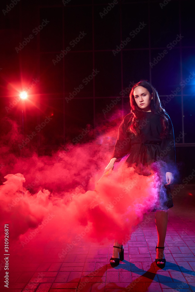 Teenage chubby girl with colored smoke torch in hand during photoshoot ...