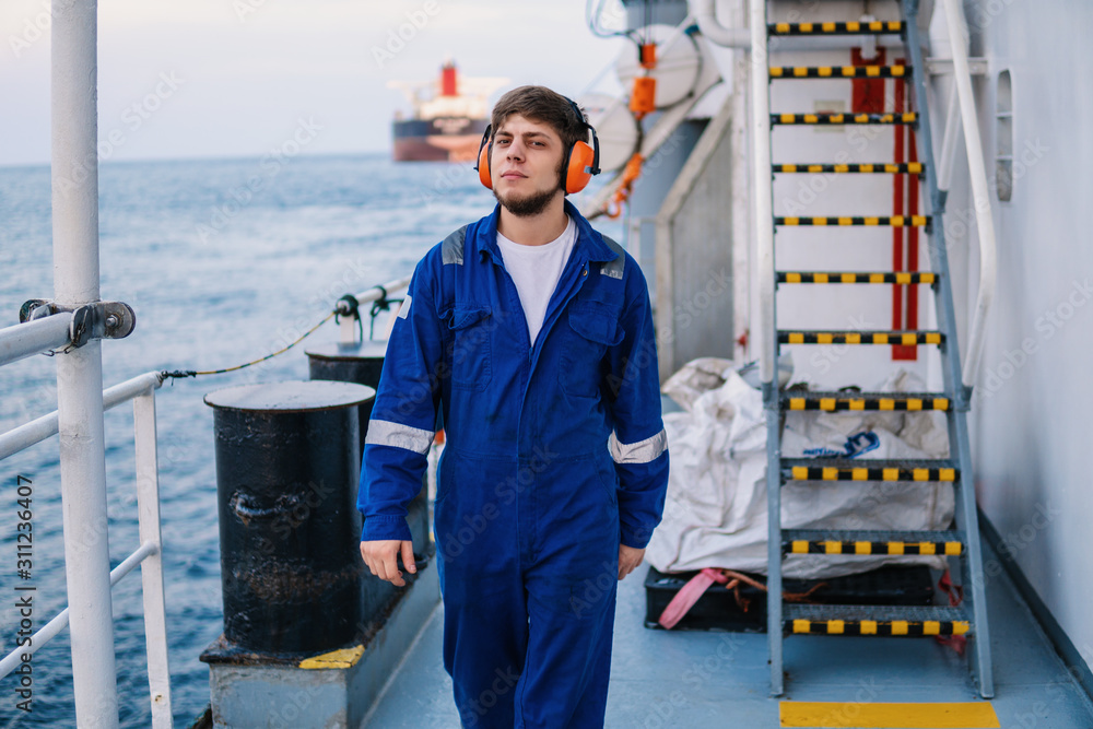 Engineer or officer on deck of offshore vessel or ship , wearing PPE ...