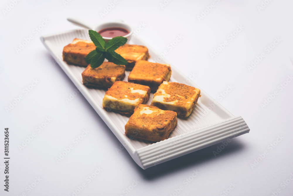 Amritsari Paneer Tikka made using cottage cheese cubes dipped in a ...