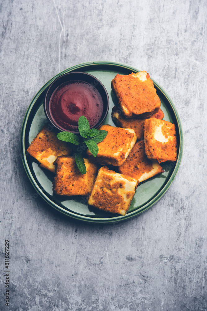 Amritsari Paneer Tikka made using cottage cheese cubes dipped in a ...