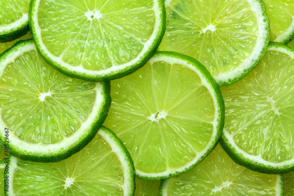 Close-up juicy Lime slices abstract background in pastel green color ...