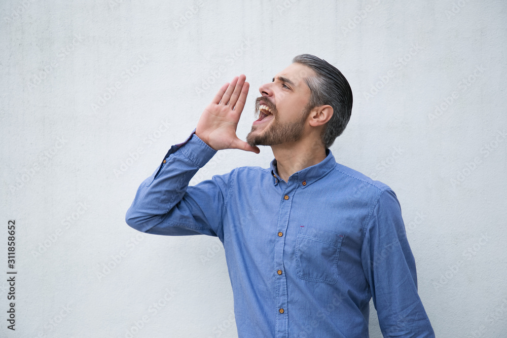 Excited man announcing news and shouting loud with hand at mouth. Grey ...